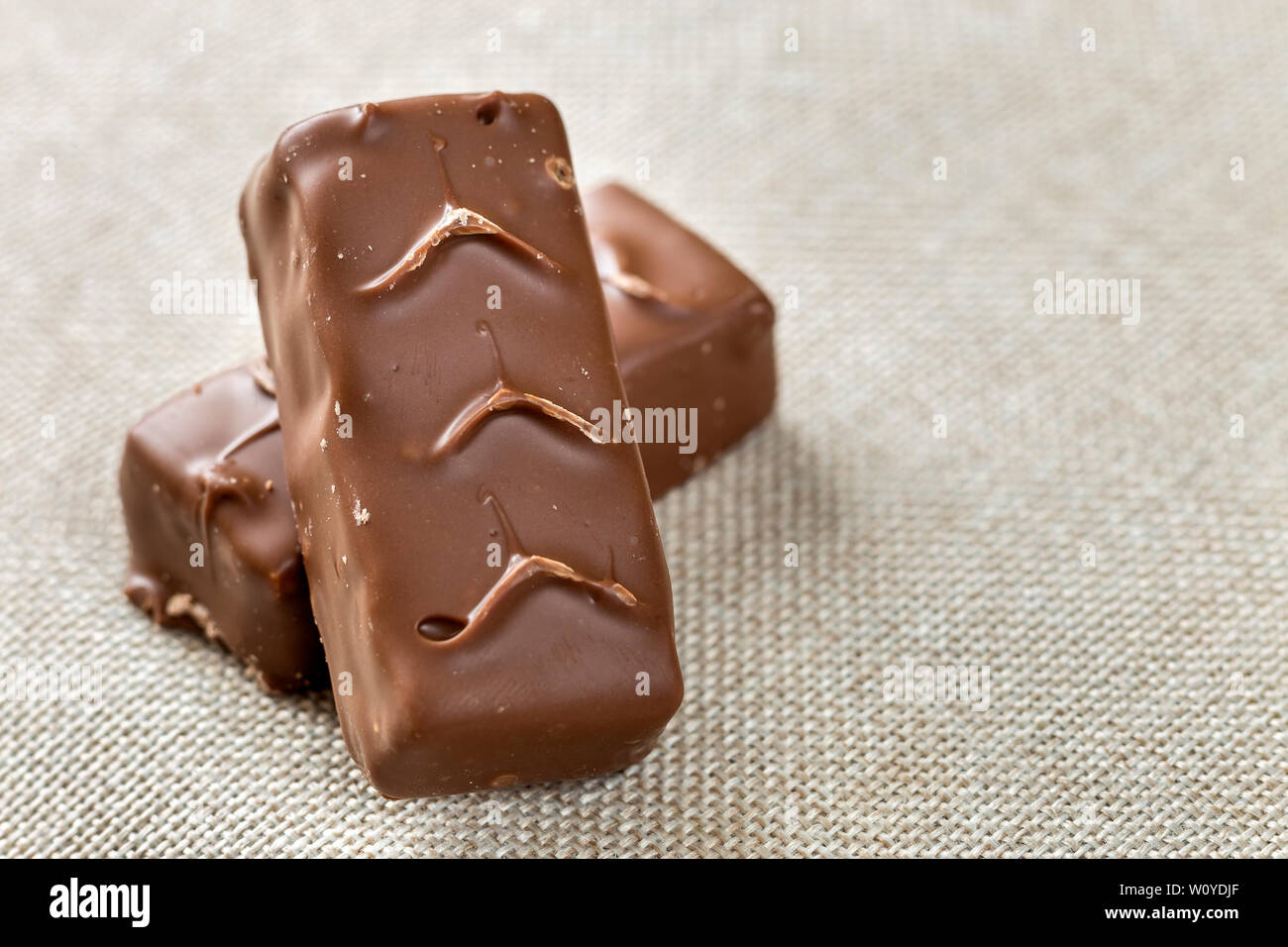 Two isolated isolated dark brown chocolate candy snickers bars on light ...