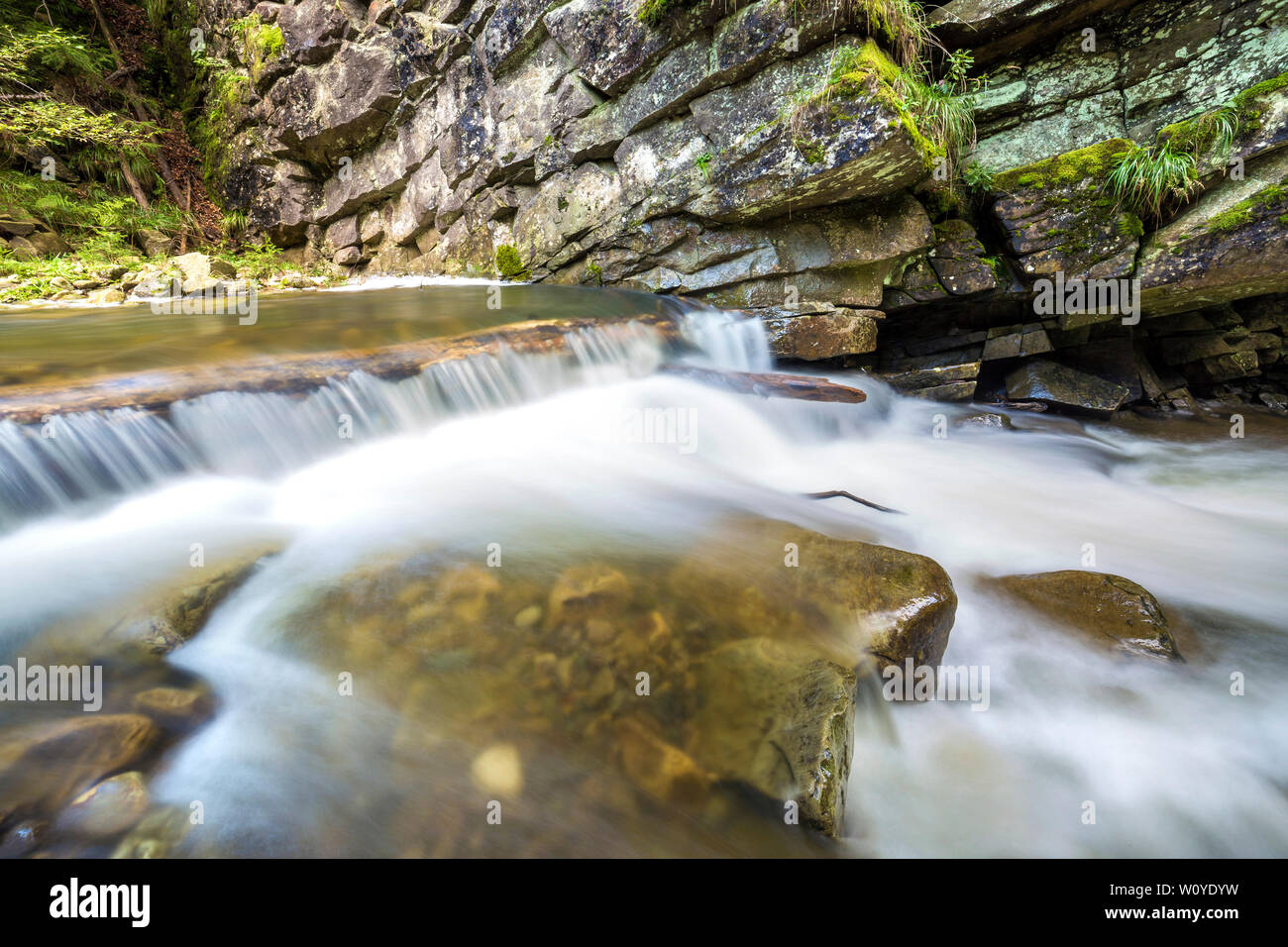 Fast flowing river stream with smooth silky water falling from big ...