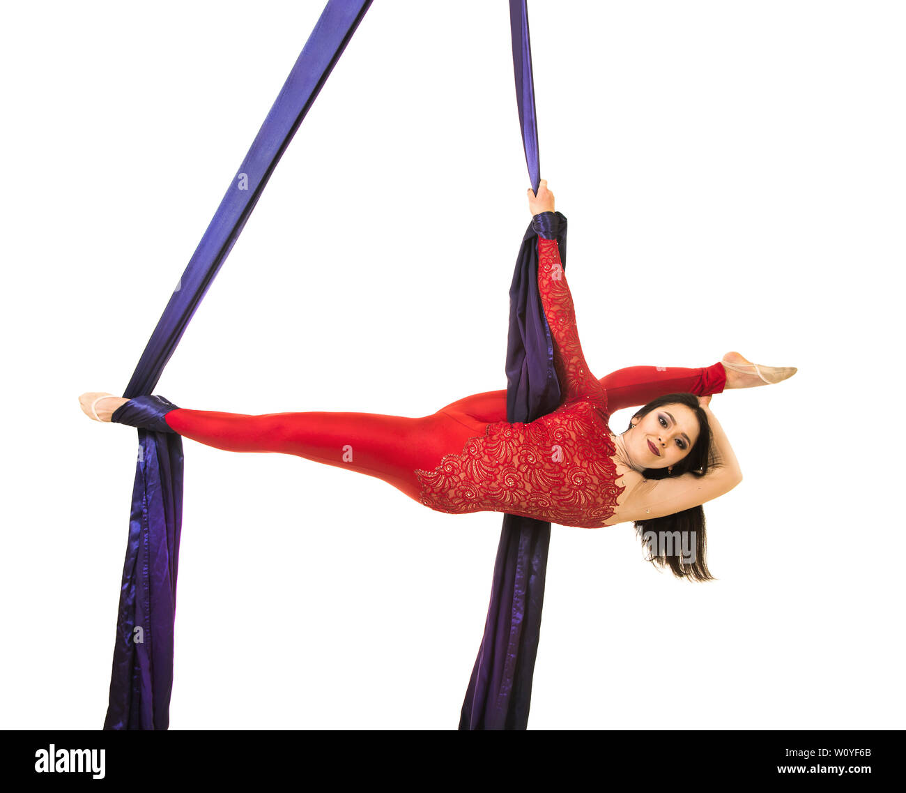A Young woman with long hair in a red suit performs gymnastic and ...