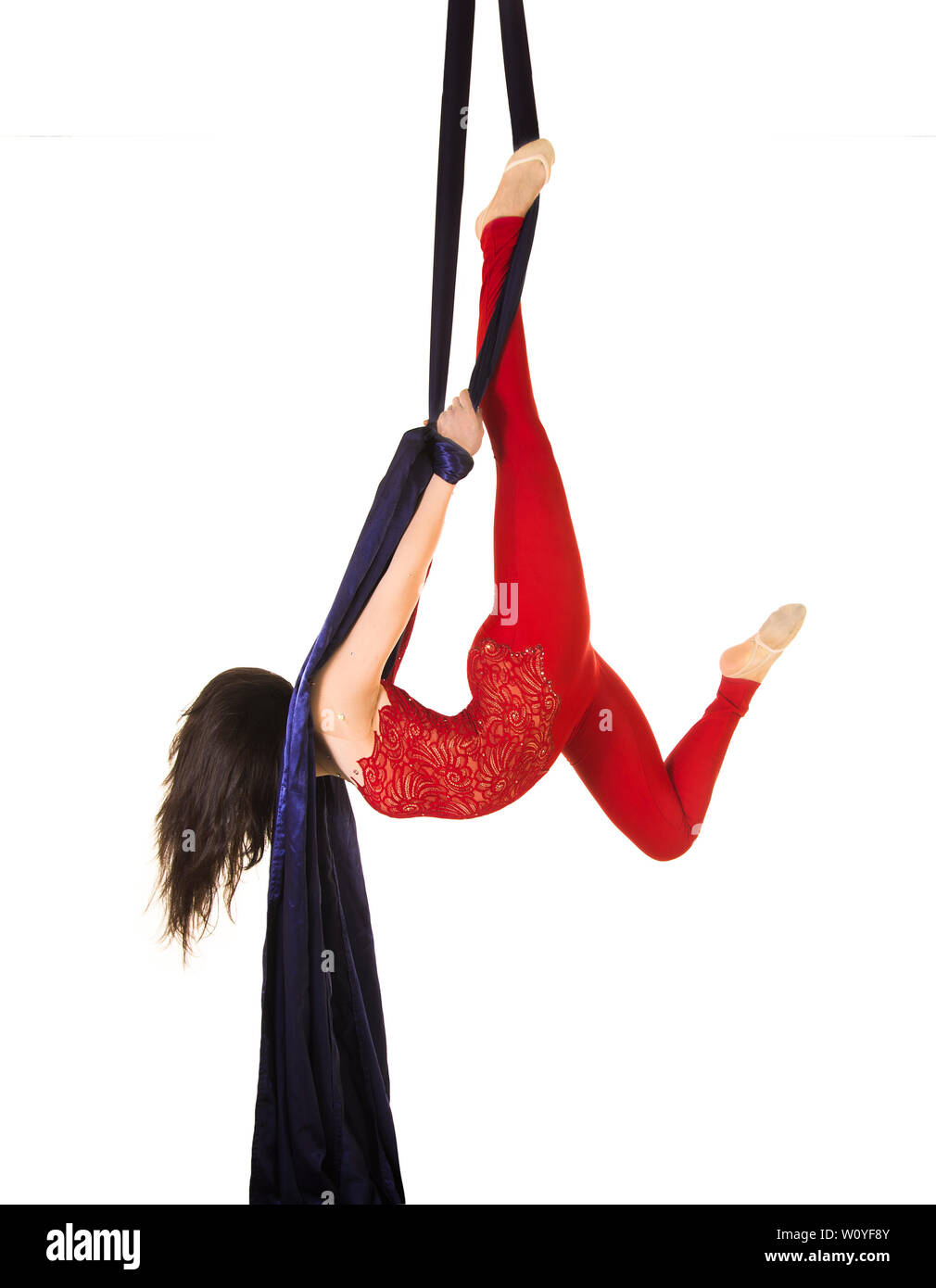 A Young woman with long hair in a red suit performs gymnastic and ...