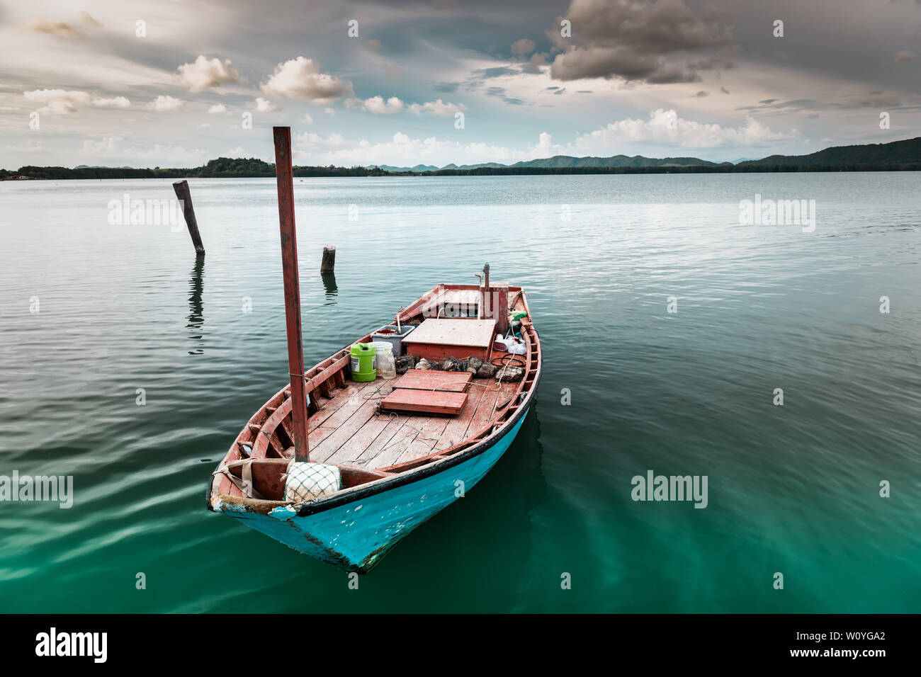 Fishery wooden boat at the shore lake scape with outdoor low lighting ...