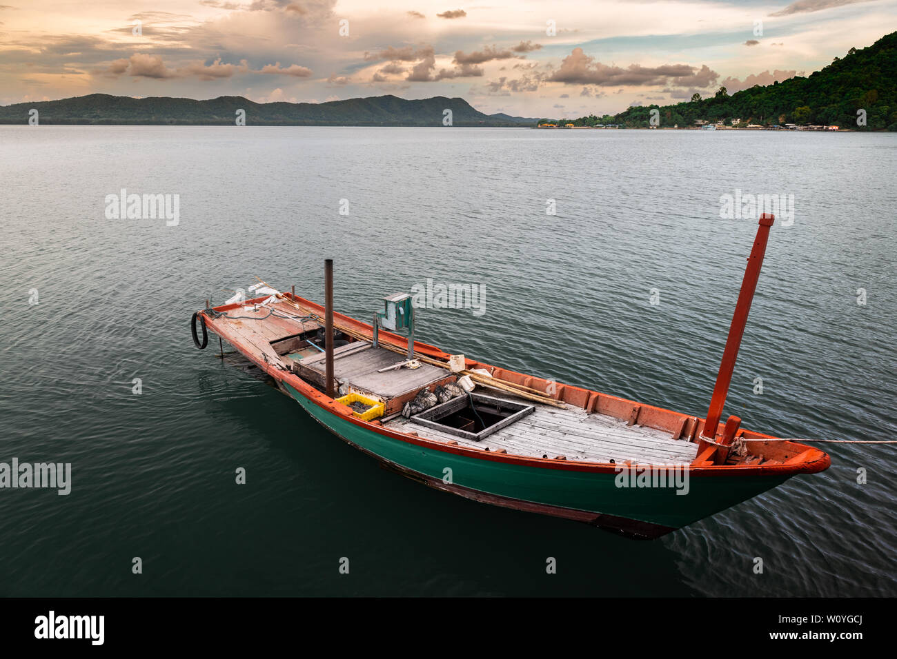 Fishery wooden boat at the shore lake scape with outdoor low lighting ...