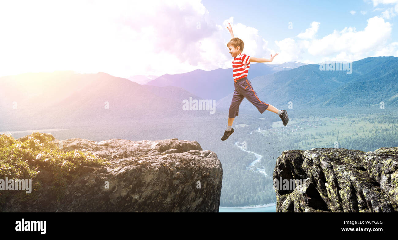 Happy little boy jumping over mountain gap. Mixed media Stock Photo - Alamy