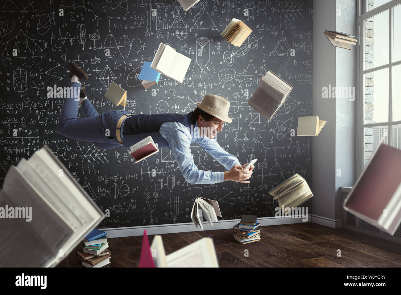 Young man in hat and casual clothes levitating in a classroom. Mixed ...