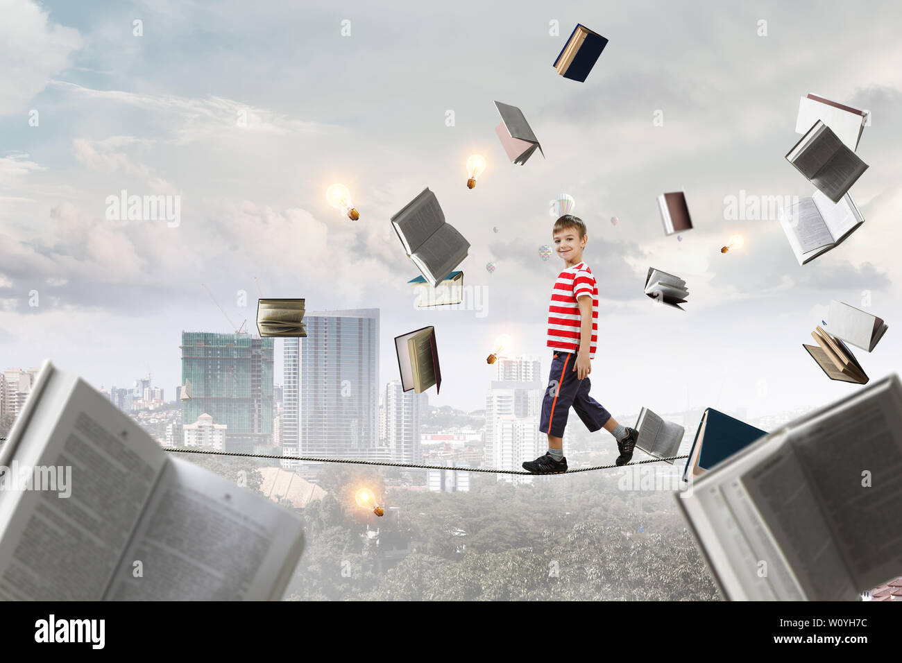 Happy little boy walking on a rope. Mixed media Stock Photo - Alamy