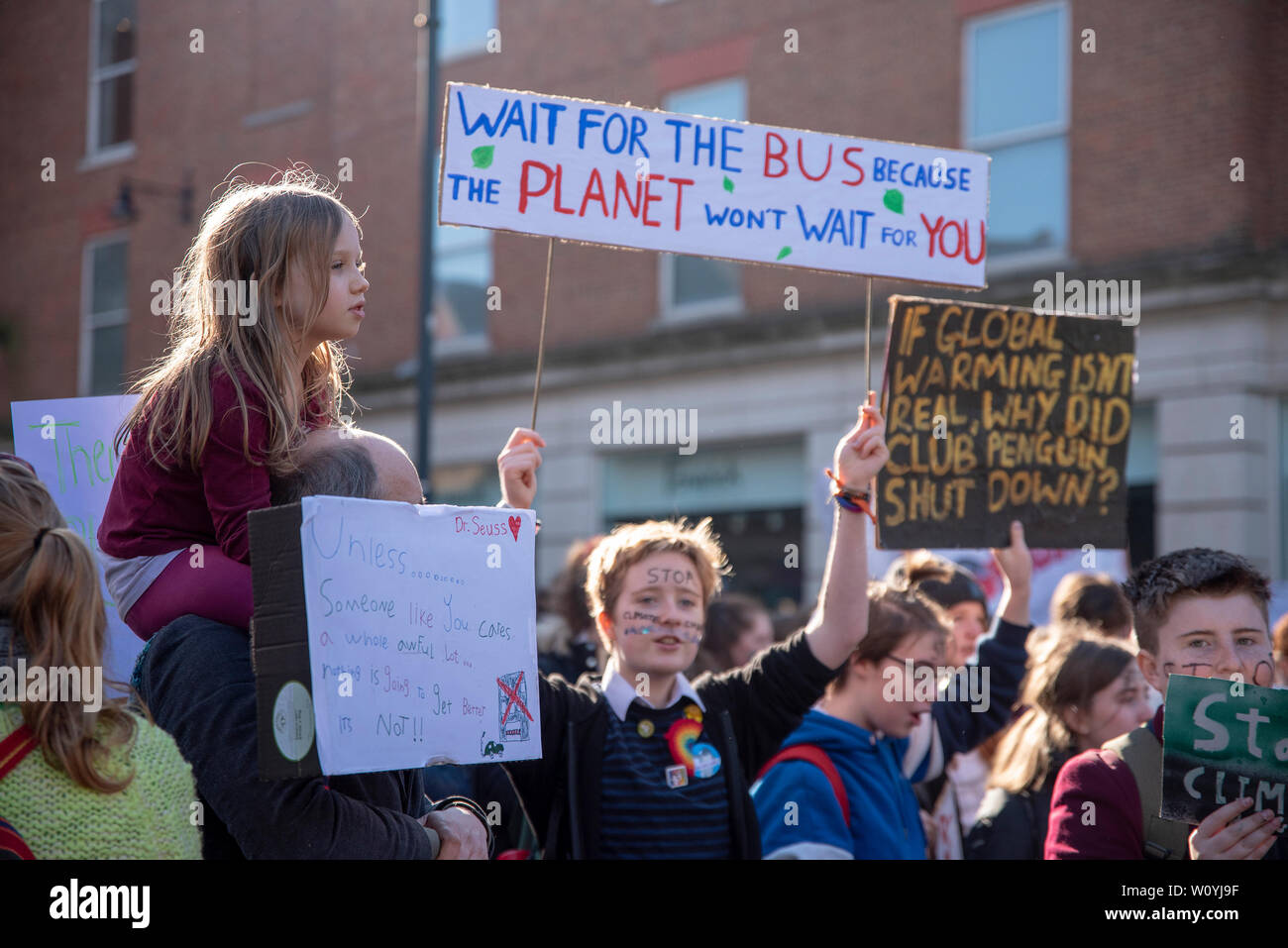 girls on her father's shoulders with placards at a Children's climate ...