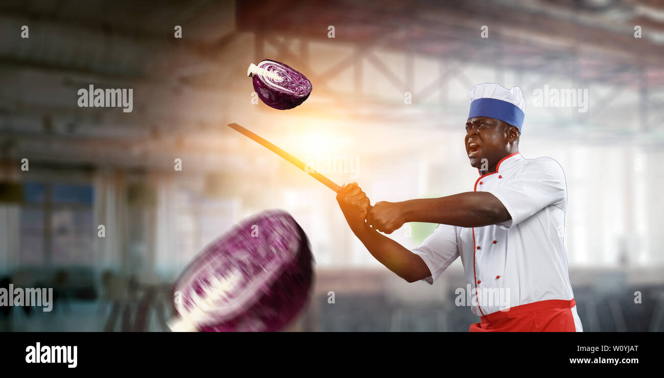 Black man triumphant, dramatic and victorous, holding a big kitchen ...