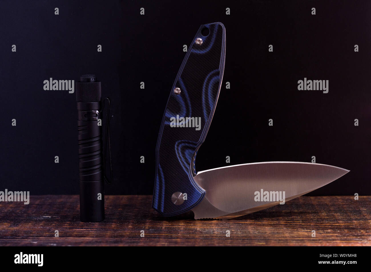 Knife in a half-complicated position and a small flashlight. Dark mood ...