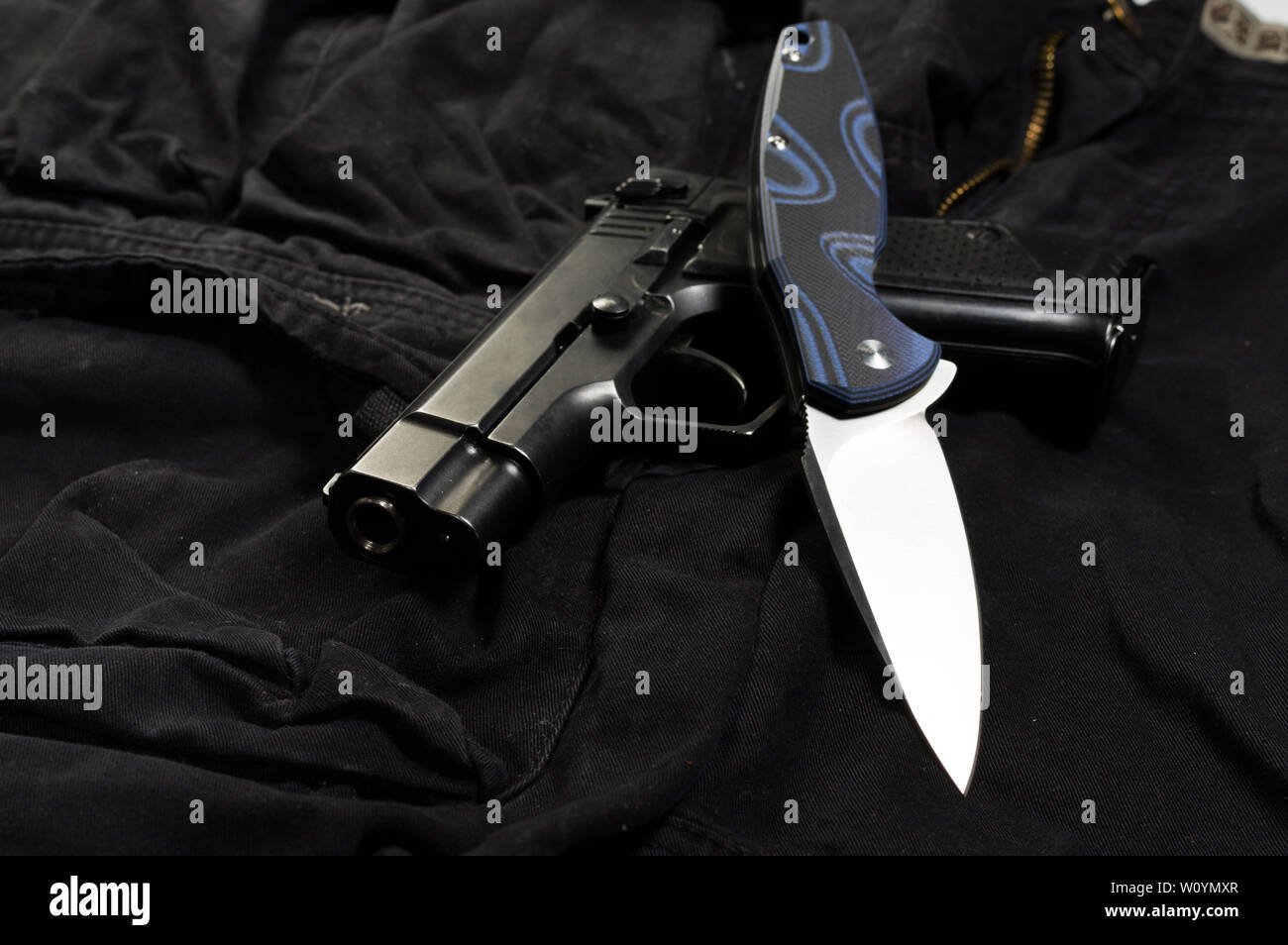 A set of weapons from a knife and pistol. White knife blade and black ...