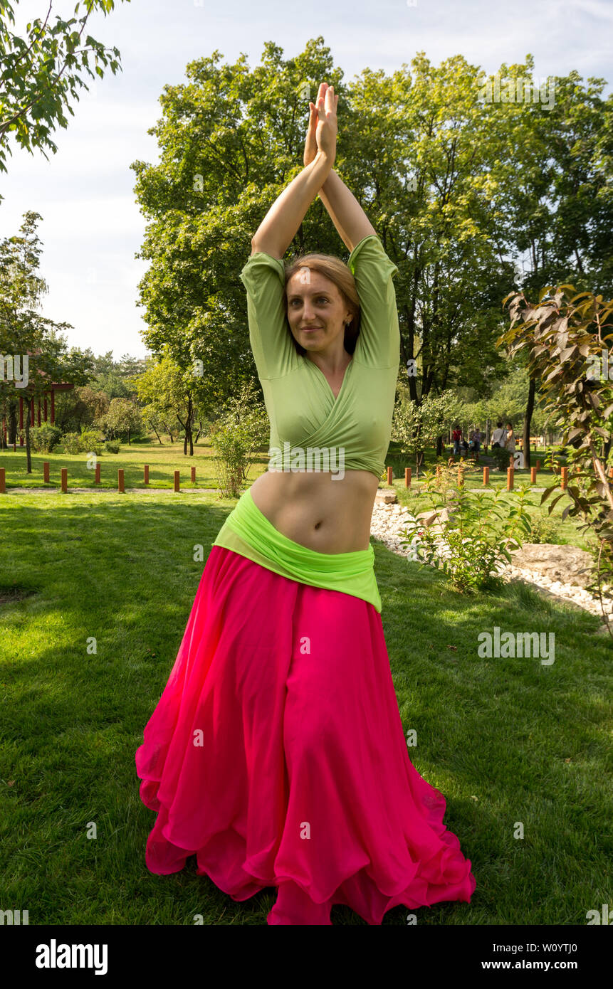 Blonde girl dancing belly dance. Dancing girl in the park. Beautiful ...