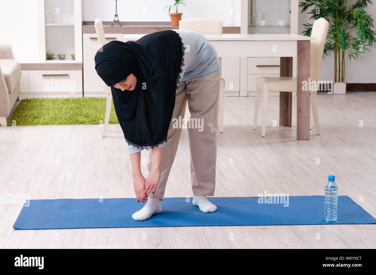 Young woman in hijab doing exercises at home Stock Photo - Alamy