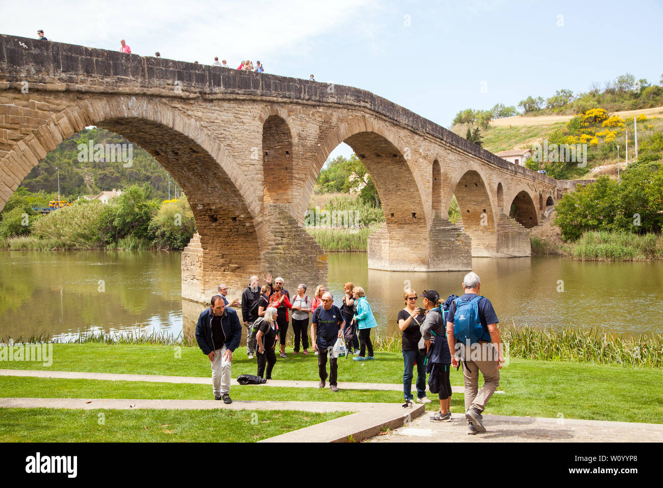 Pilgrims bellow the medieval bridge in the town of Puente la Reina ...