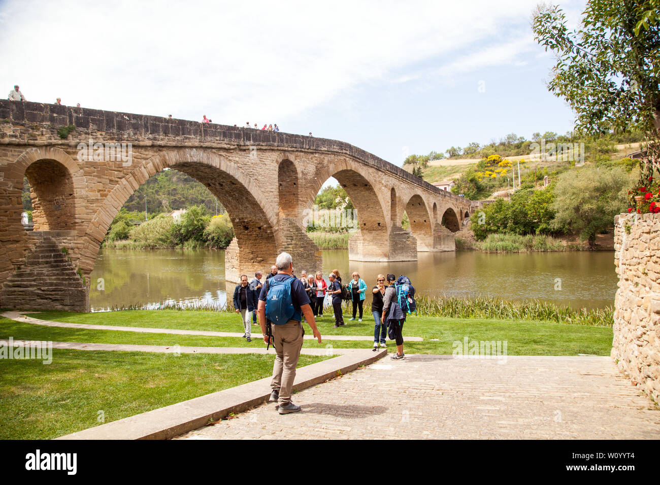 Pilgrims bellow the medieval bridge in the town of Puente la Reina ...
