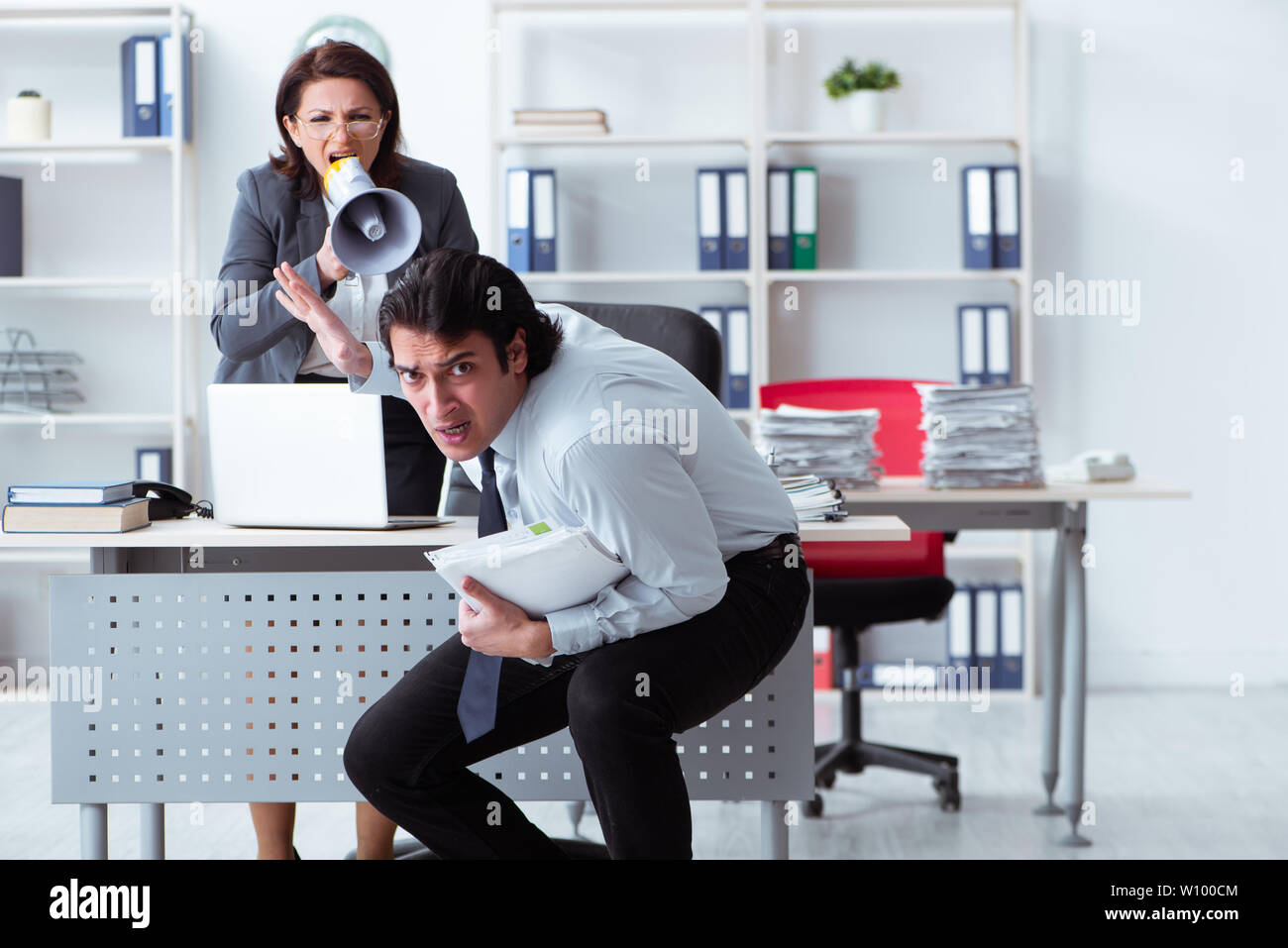 Old female boss and young male employee in the office Stock Photo - Alamy