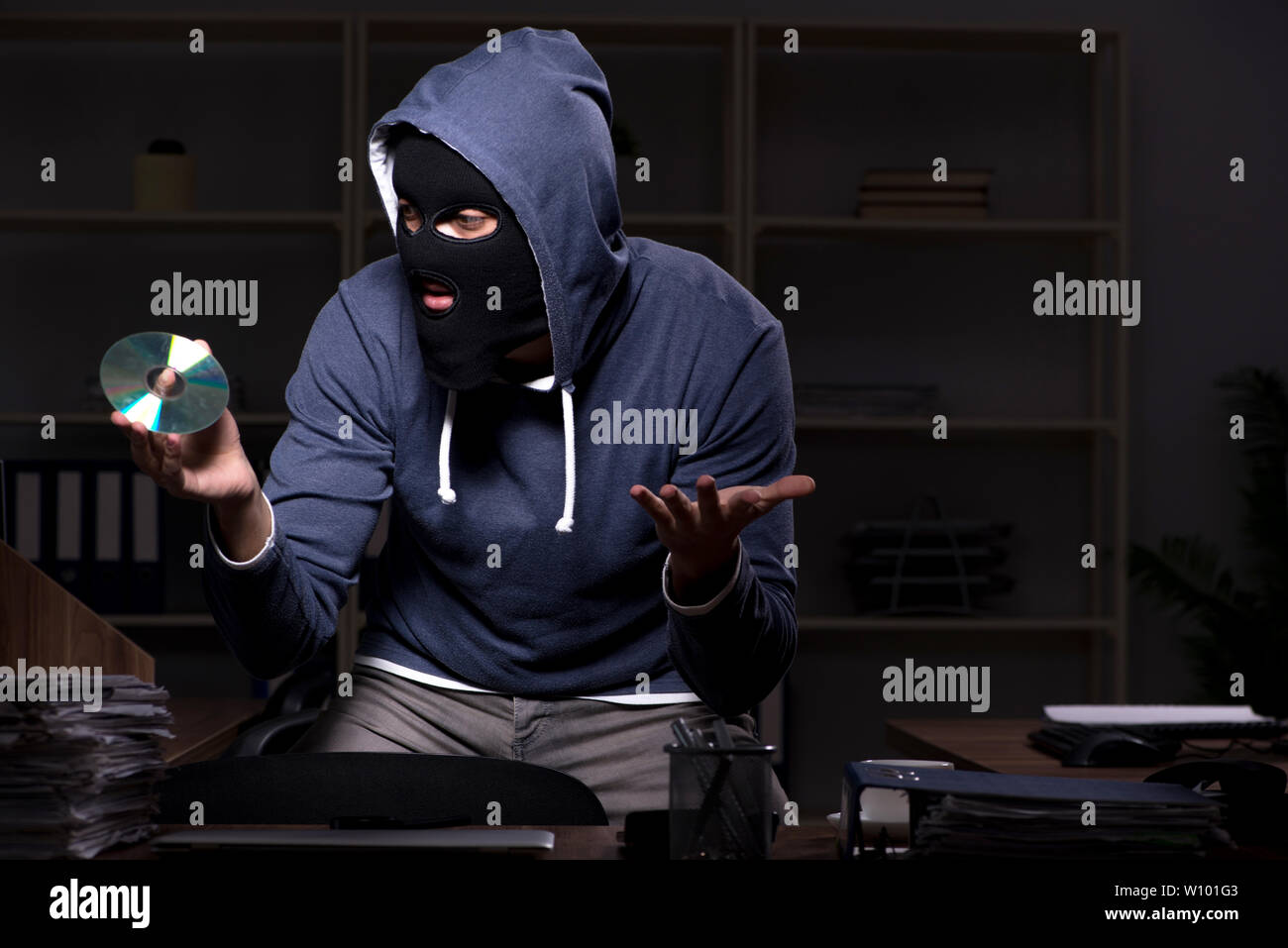 Male thief in balaclava in the office night time Stock Photo - Alamy