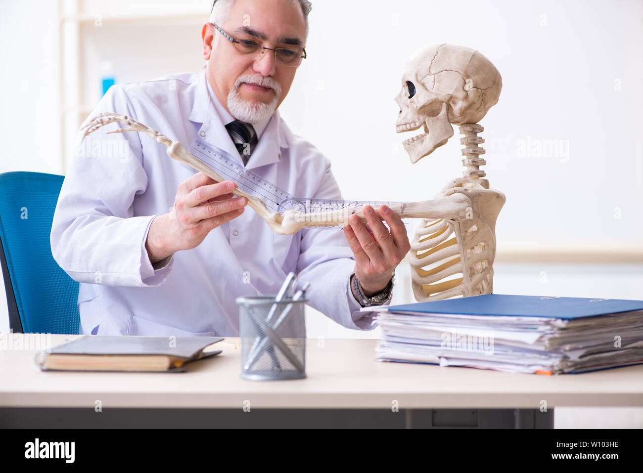 The aged male doctor with skeleton Stock Photo - Alamy