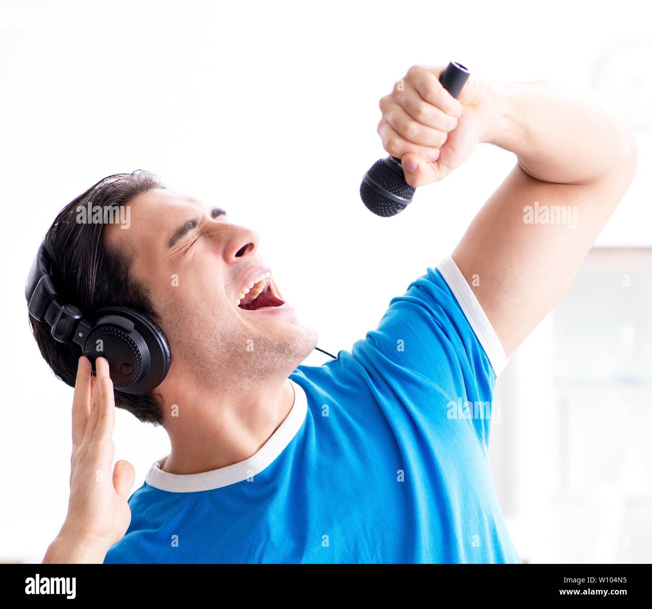 Young man singing at home karaoke Stock Photo - Alamy