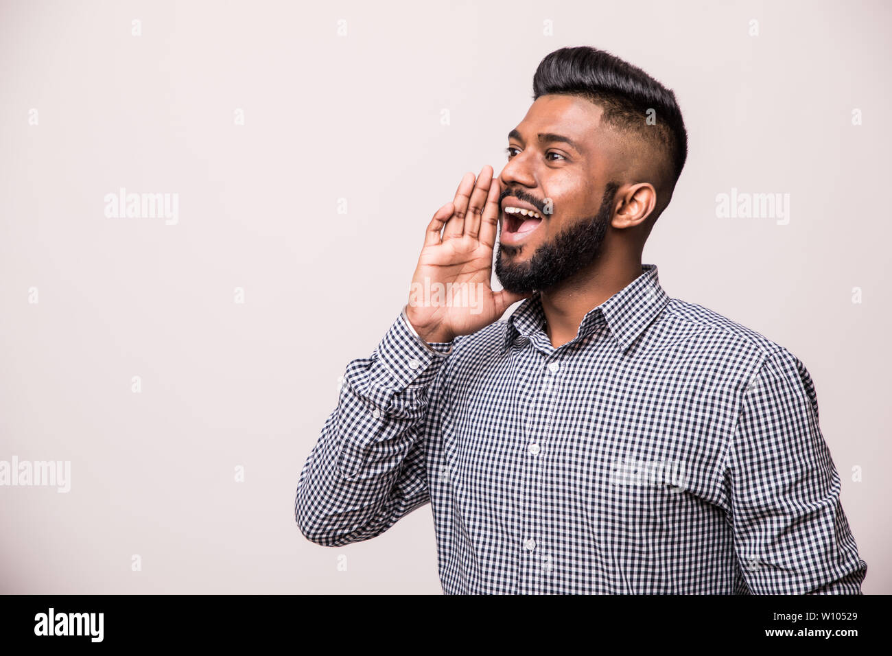 An angry man pulling his hair and screaming, isolated on a white ...