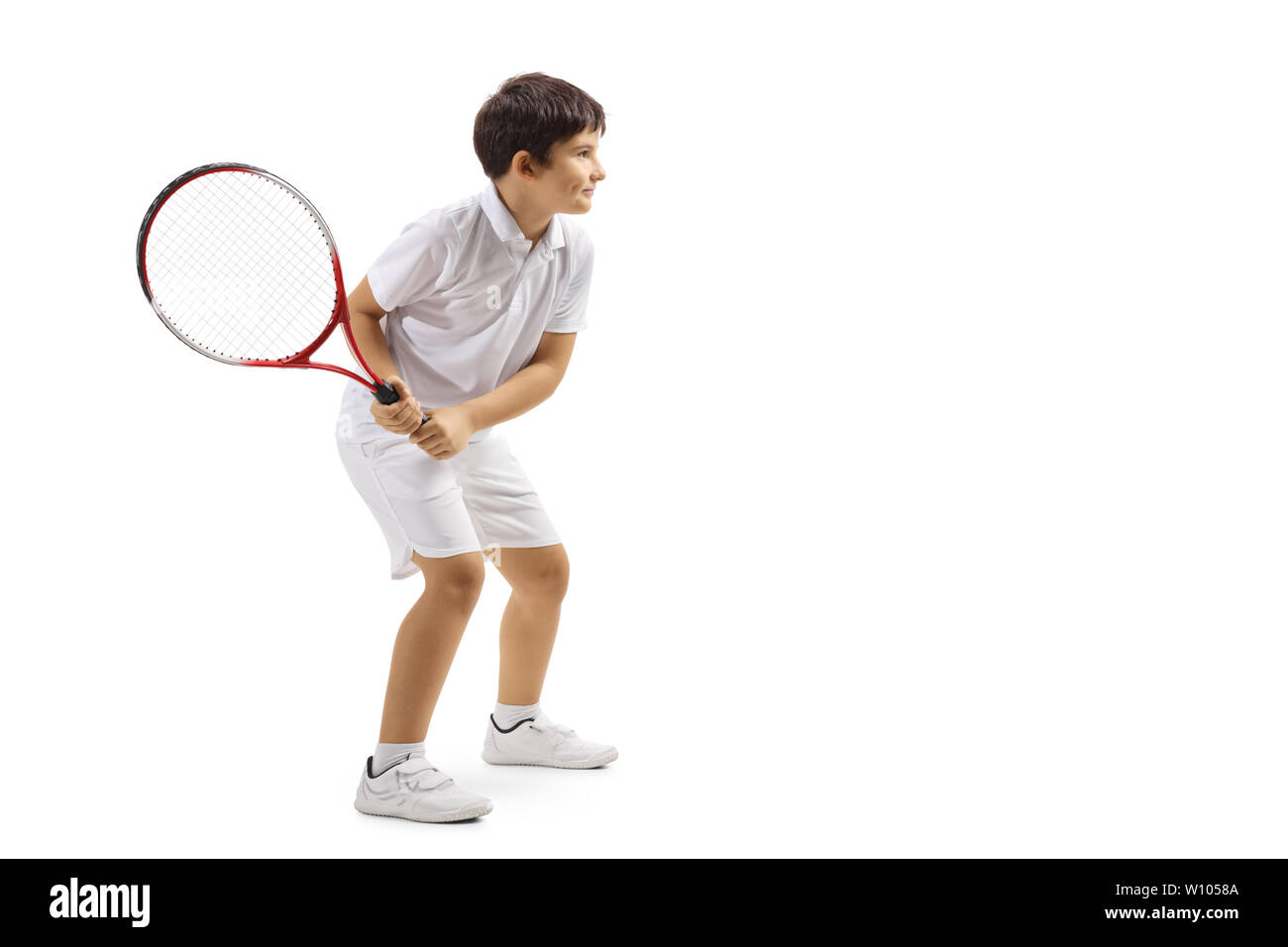 Full length profile shot of a boy playing tennis isolated on white ...