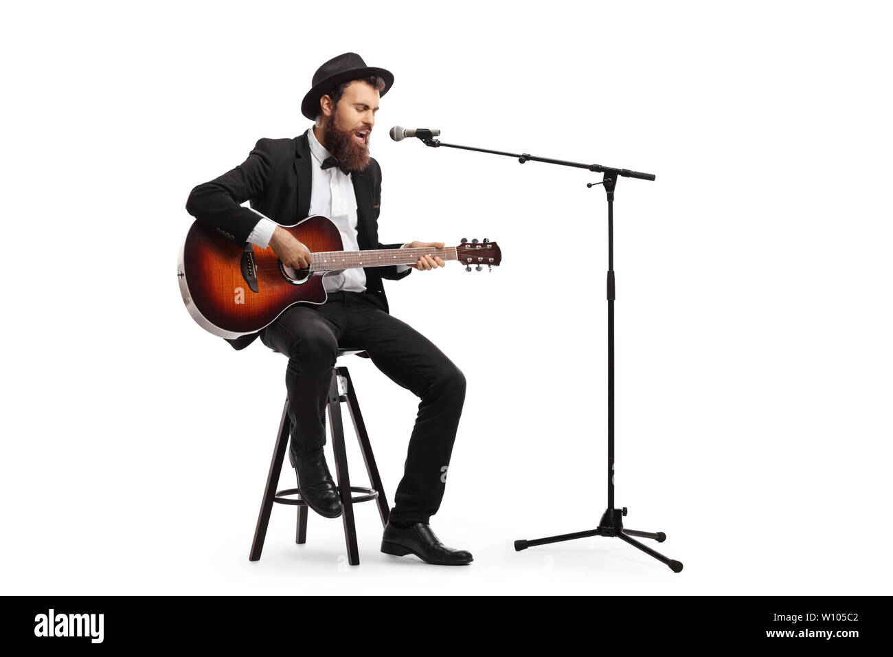 Full length shot of a musician singing on a microphone and playing an ...