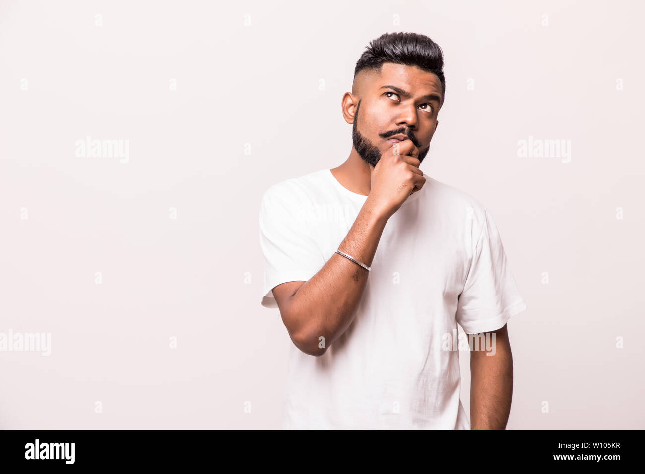 Impressed man with a confident look , putting his fingers under his ...