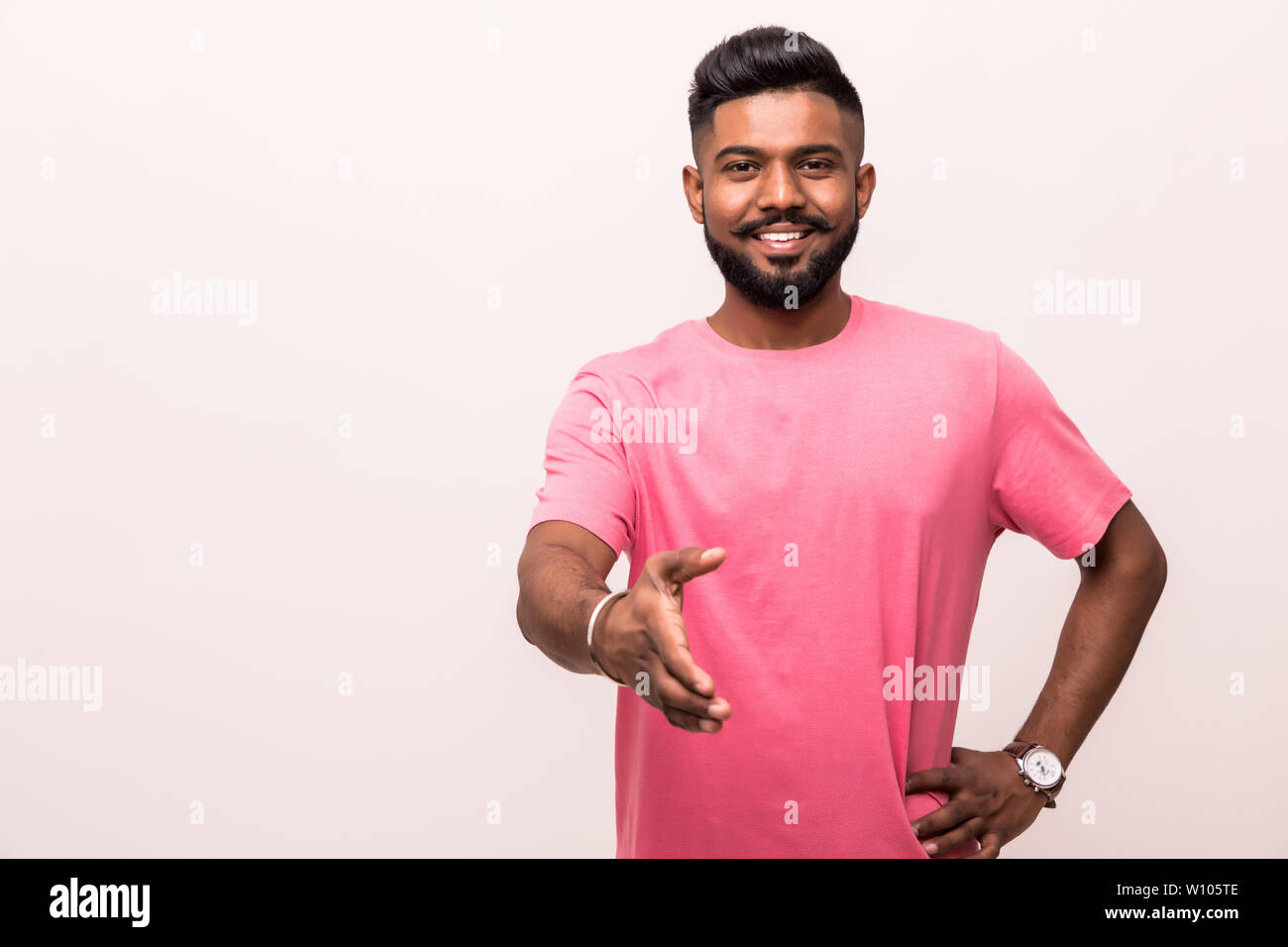 Closeup portrait of a handsome casual guy extending hand for handshake ...