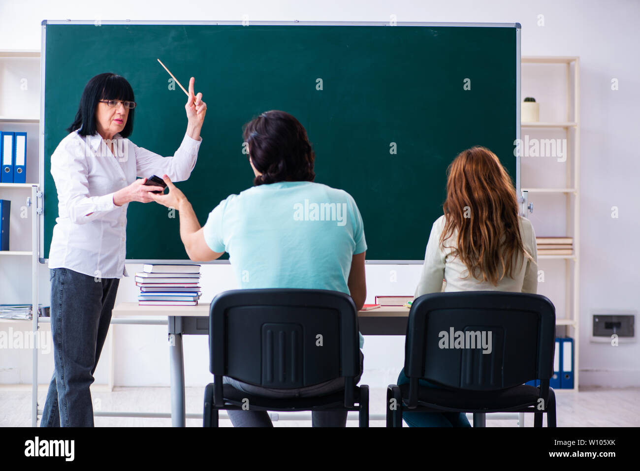 Old teacher and students in the classroom Stock Photo - Alamy