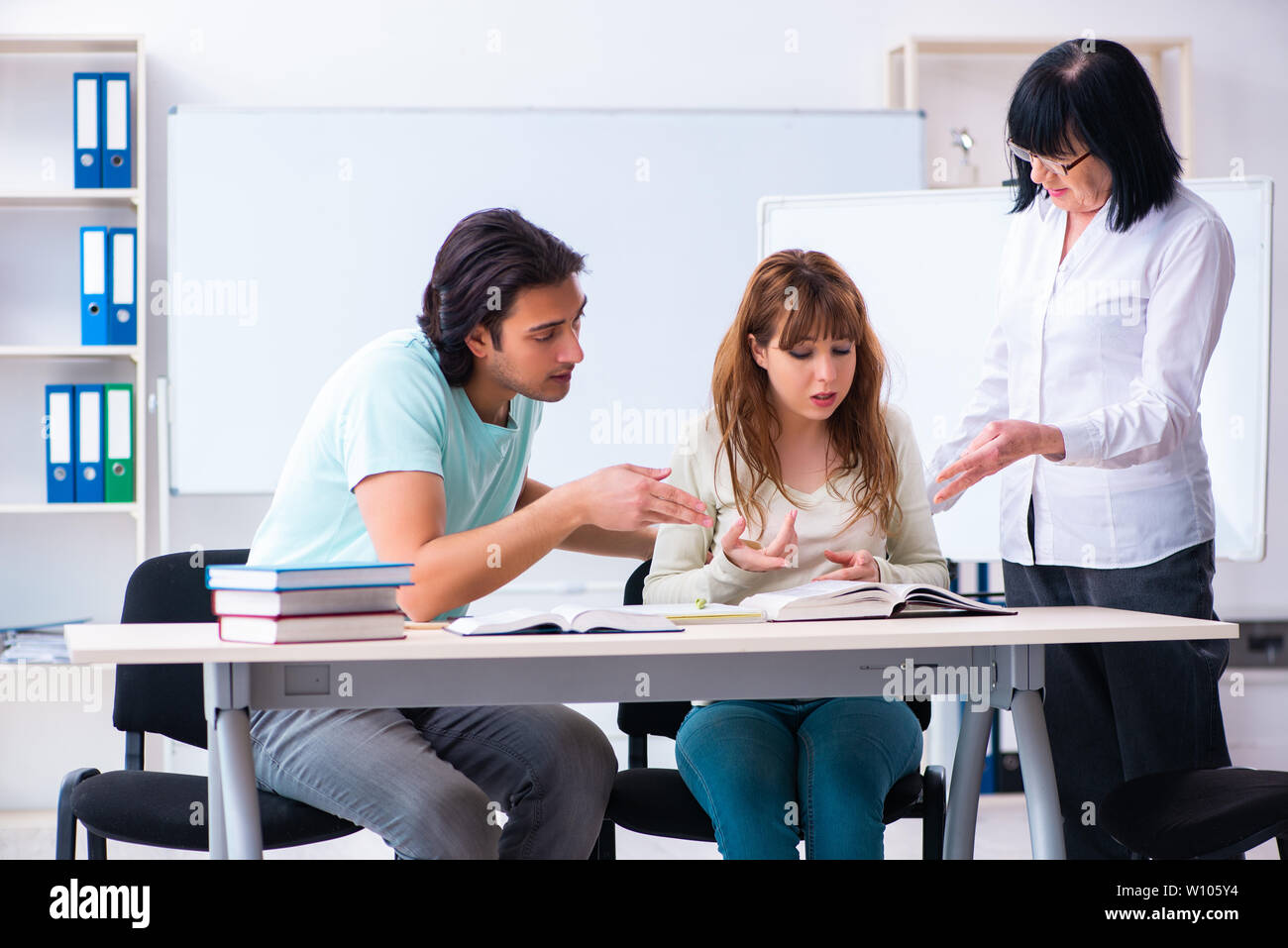 Old teacher and students in the classroom Stock Photo - Alamy