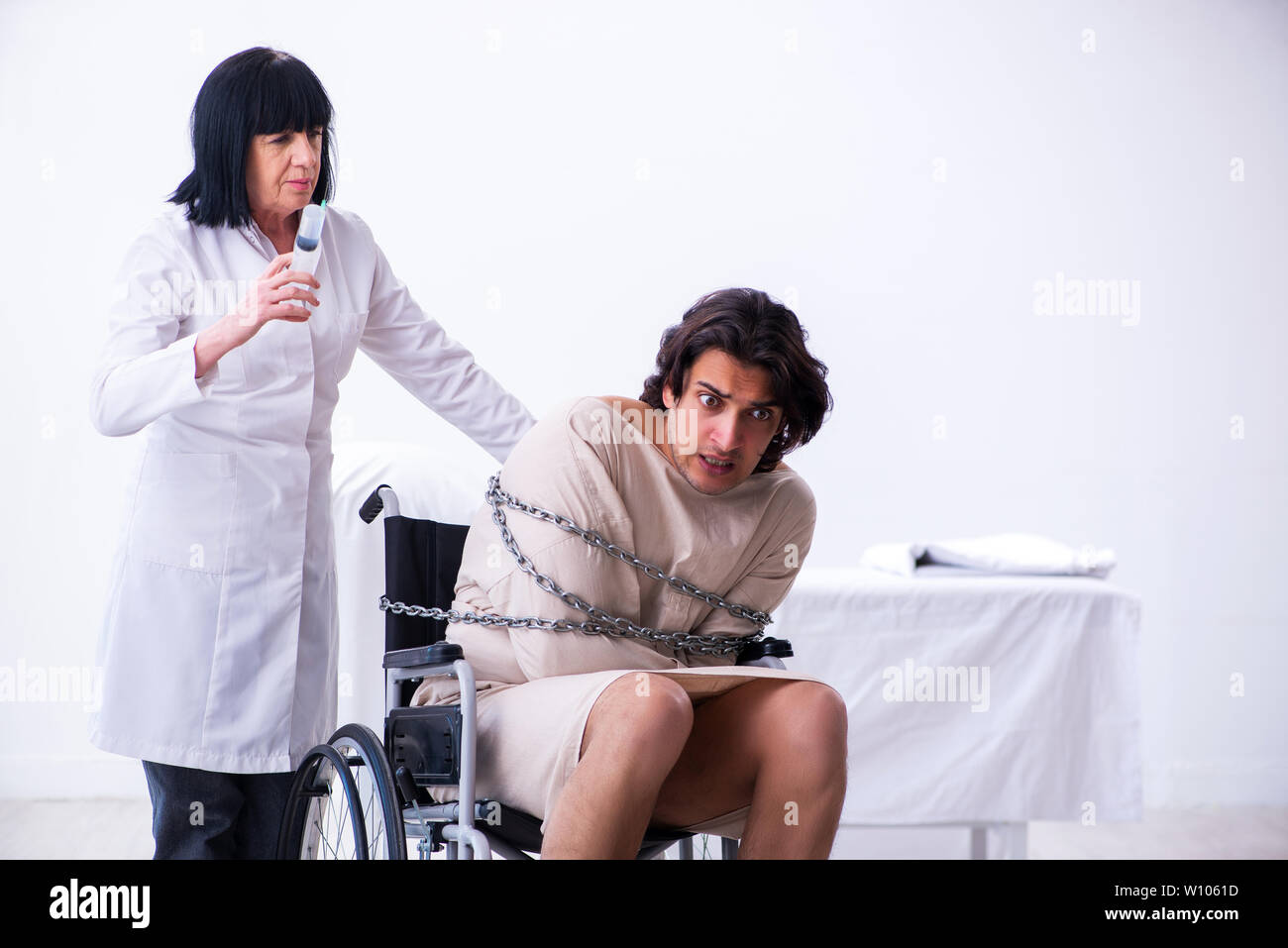Old female psychiatrist visiting young male patient Stock Photo - Alamy