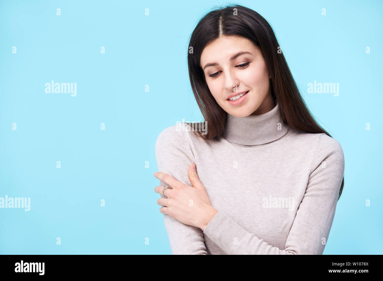 studio portrait of a beautful caucasian woman, looking down, smiling ...