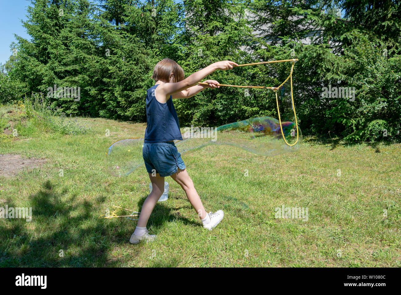 Fun with bubbles in the garden. Sunny day and shimmering soap bubbles ...