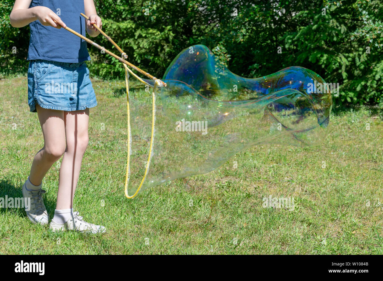 Fun with bubbles in the garden. Sunny day and shimmering soap bubbles ...