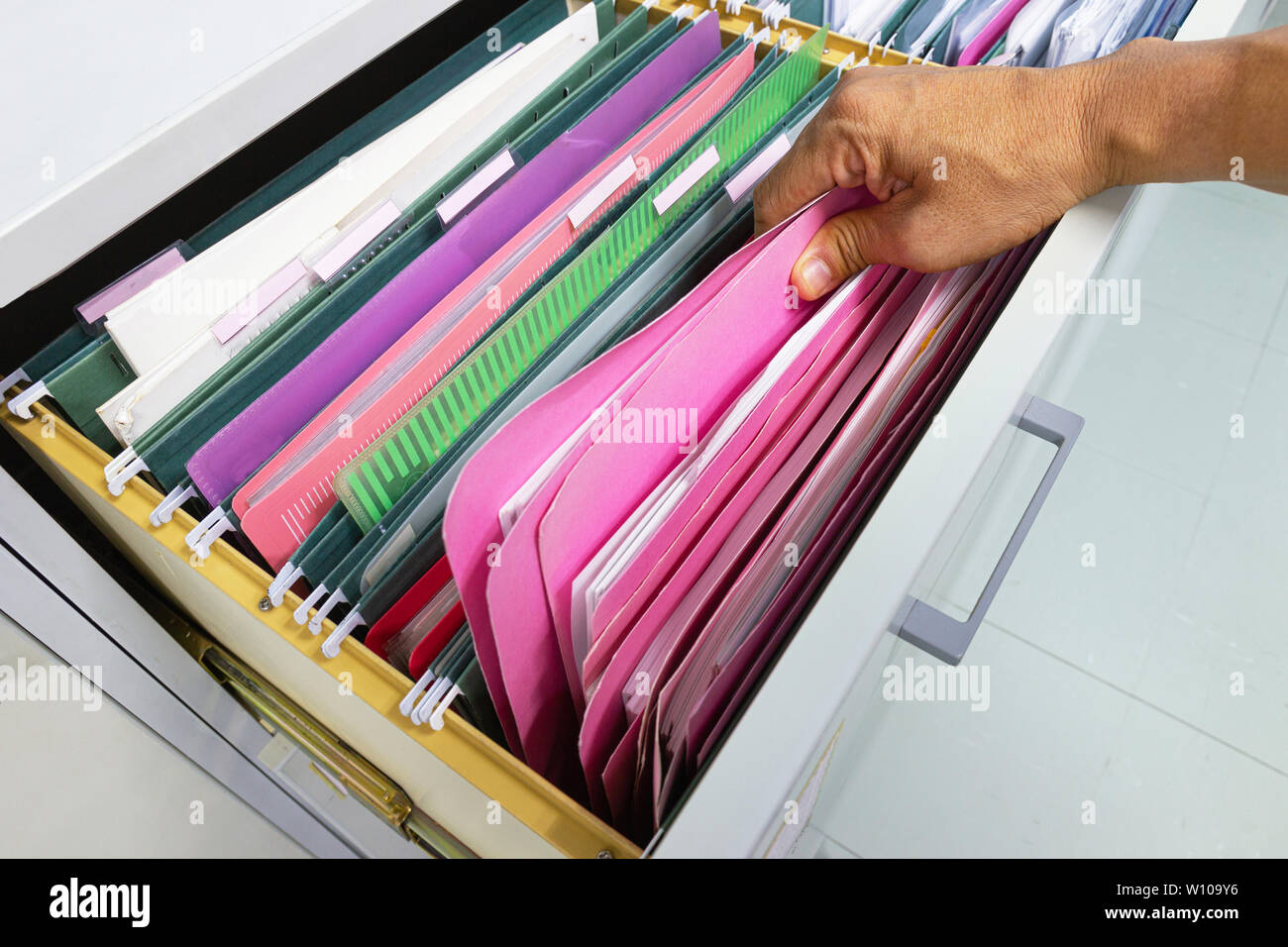 Hand of Man Search files document in a file cabinet in work office ...