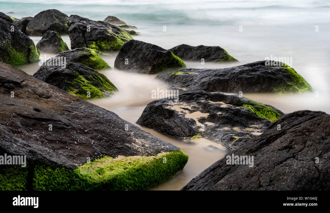 Black rocks at Point Danger in NSW Australia Stock Photo - Alamy