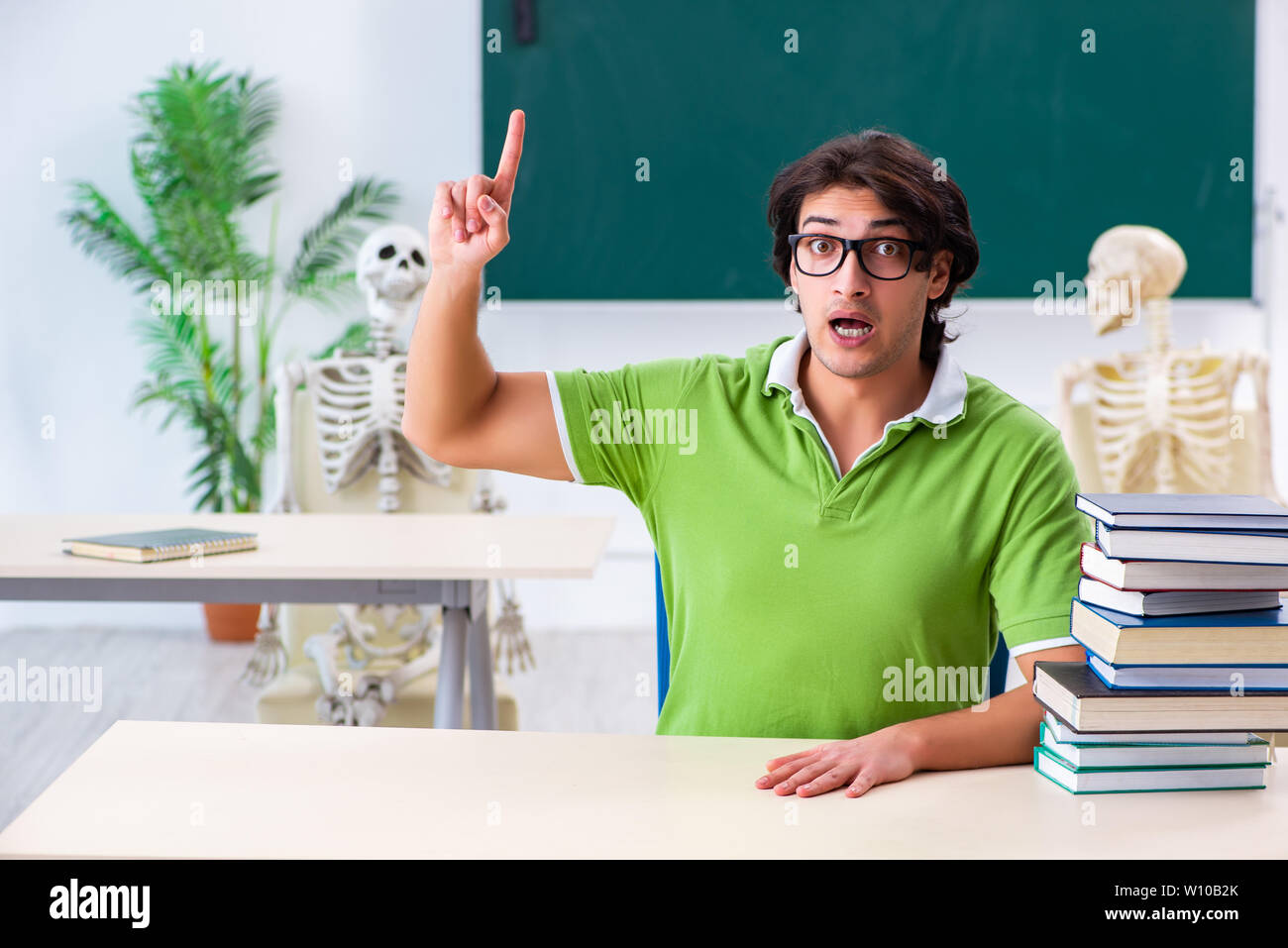 Funny male student in the classroom with skeleton Stock Photo - Alamy