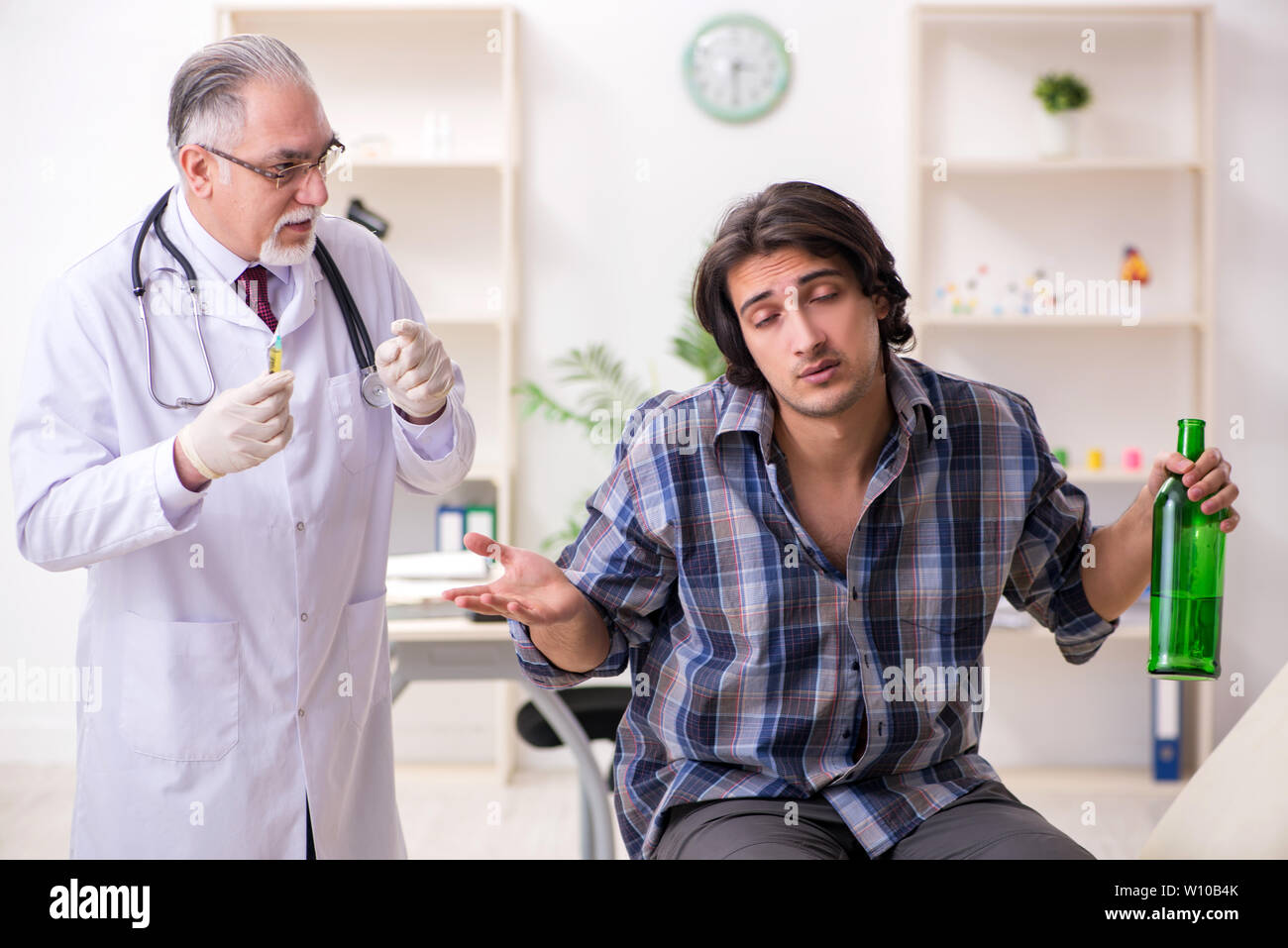 Young male alcoholic visiting old doctor Stock Photo - Alamy
