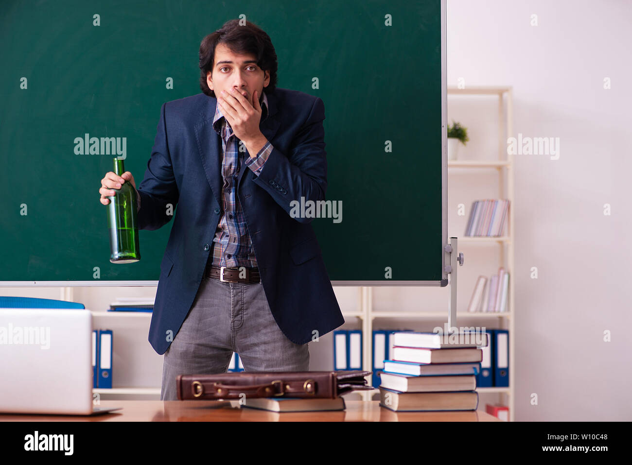 Male teacher drinking in the classroom Stock Photo - Alamy