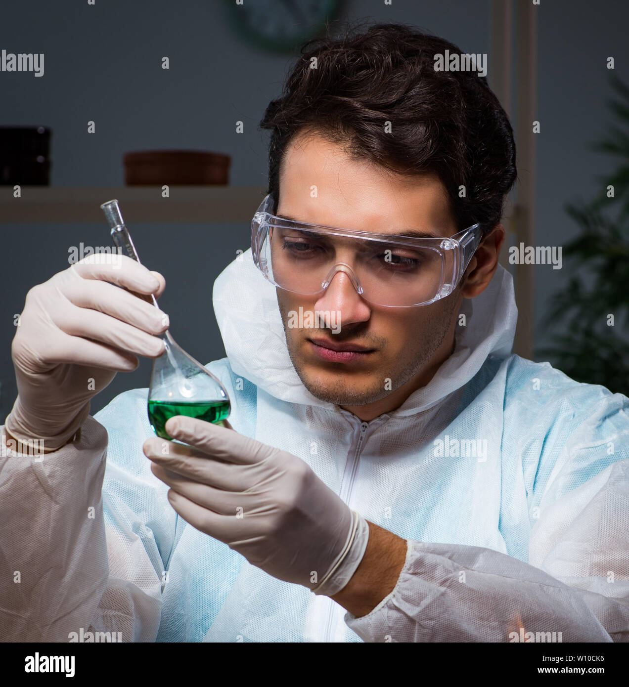 Forensic investigator working in lab looking for evidence Stock Photo ...