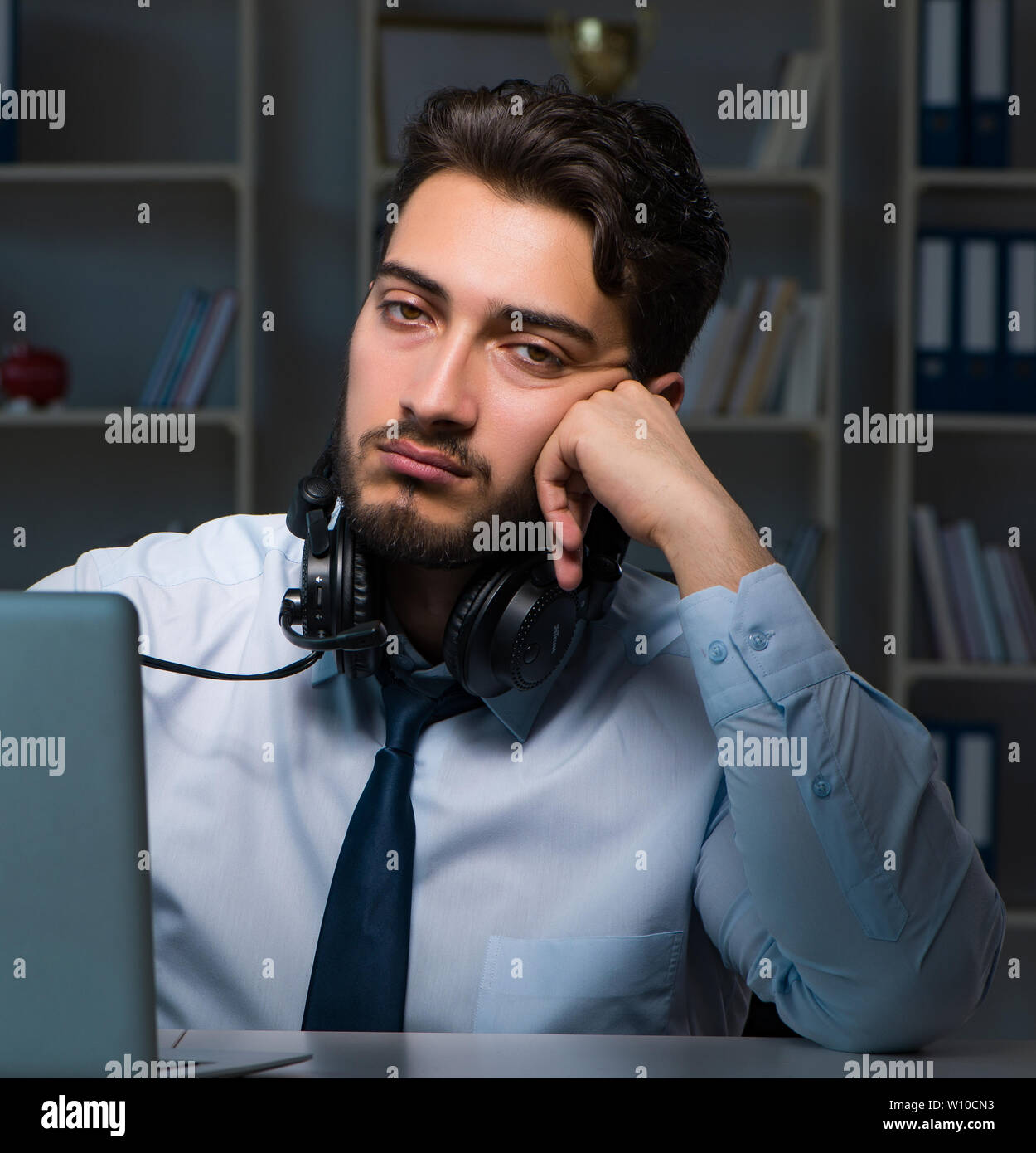 Young man in call center concept working late overtime in office Stock ...