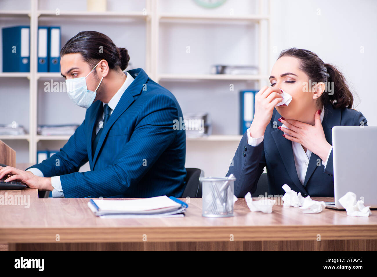 Two employees suffering at workplace Stock Photo - Alamy