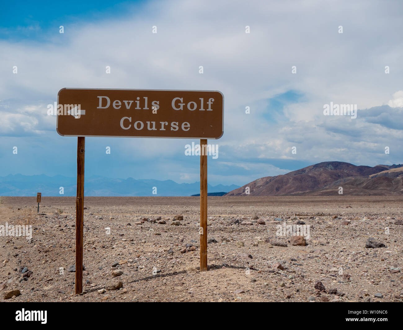 Devils Golf Course road sign and landscape with clouds in the desert at ...