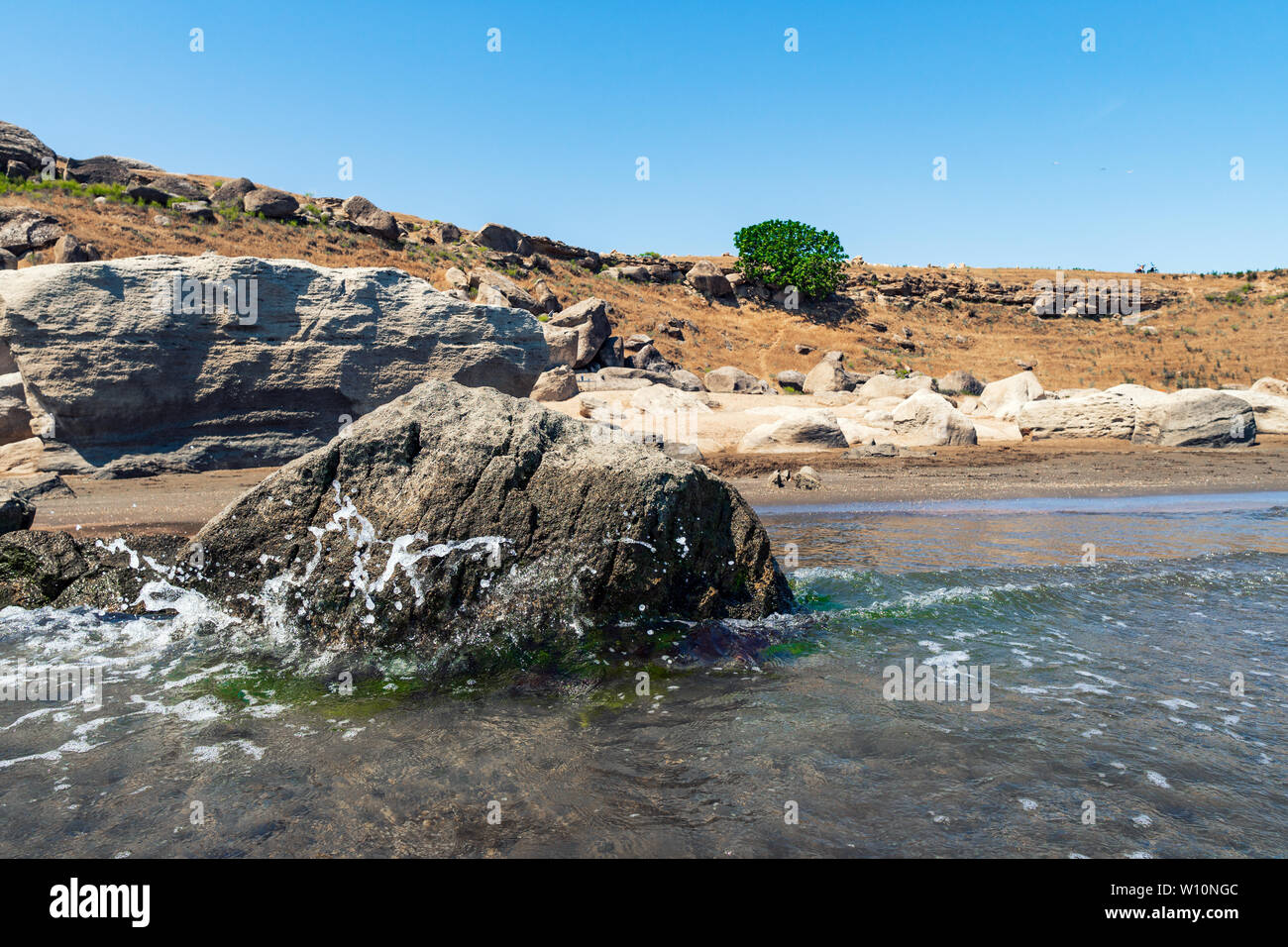 Rocky seashore with clear water and waves Stock Photo - Alamy