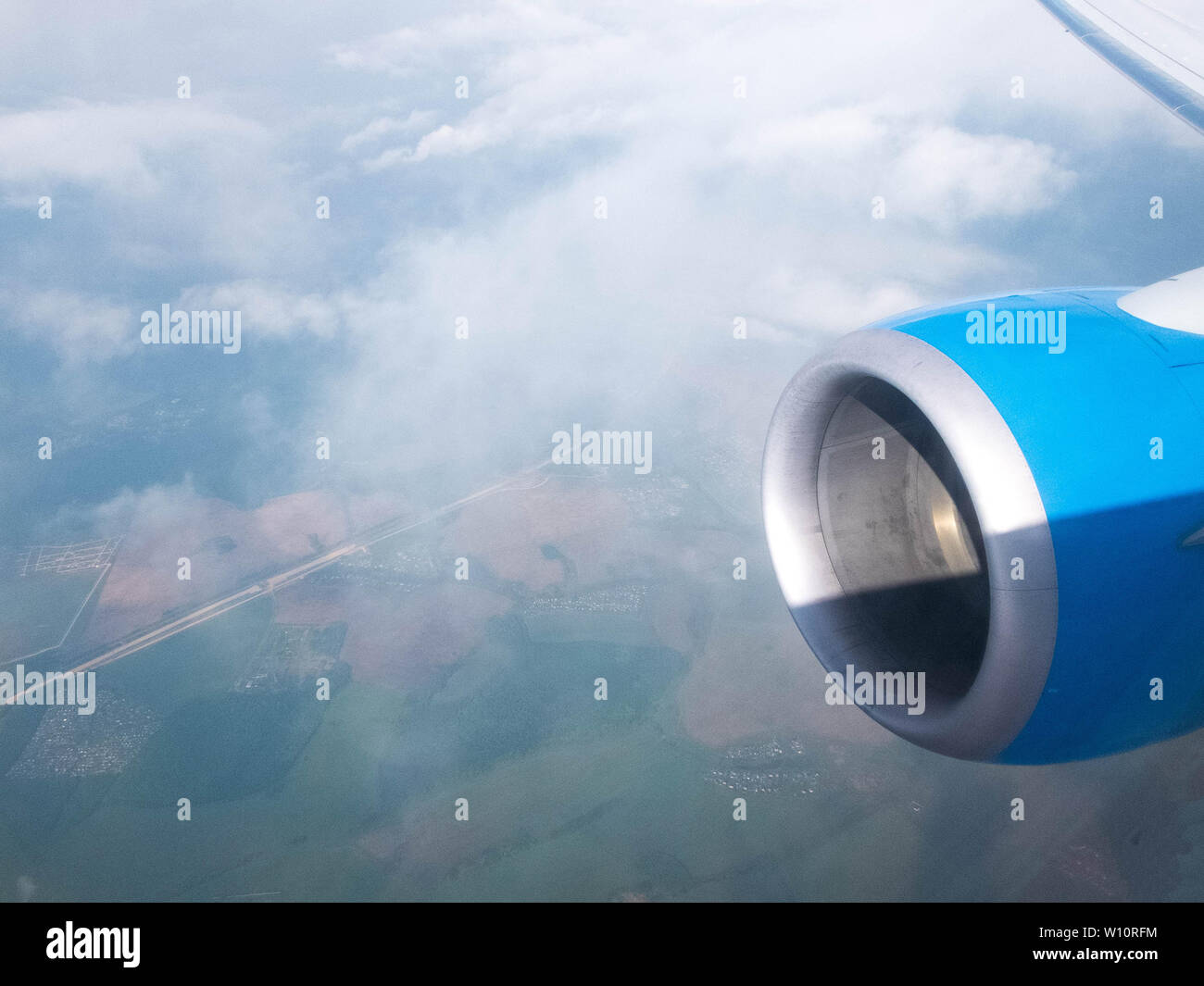 Clouds,roads and fields, engine and wing of plane. Aerial view from ...