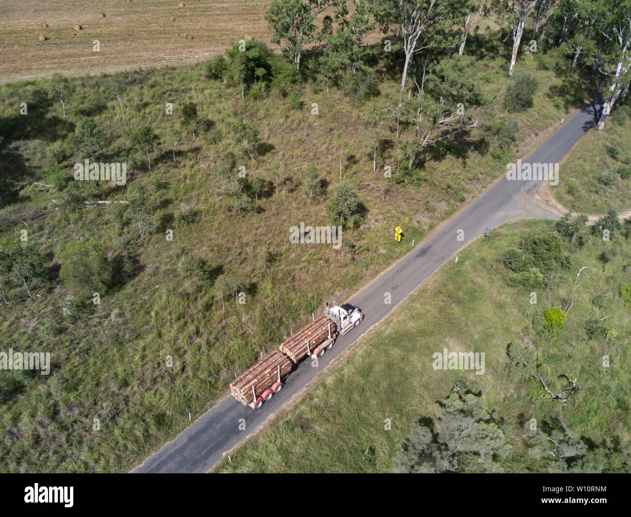 Aerial of a fully loaded Logging truck crossing causeway over the ...