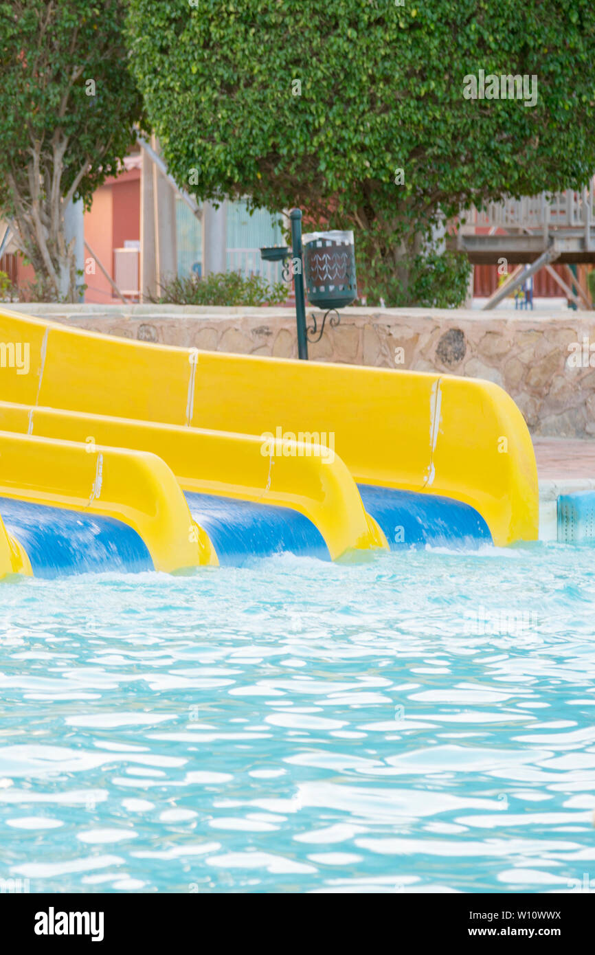 Colourful plastic slides in aquapark in the sunset. sliders, water park ...