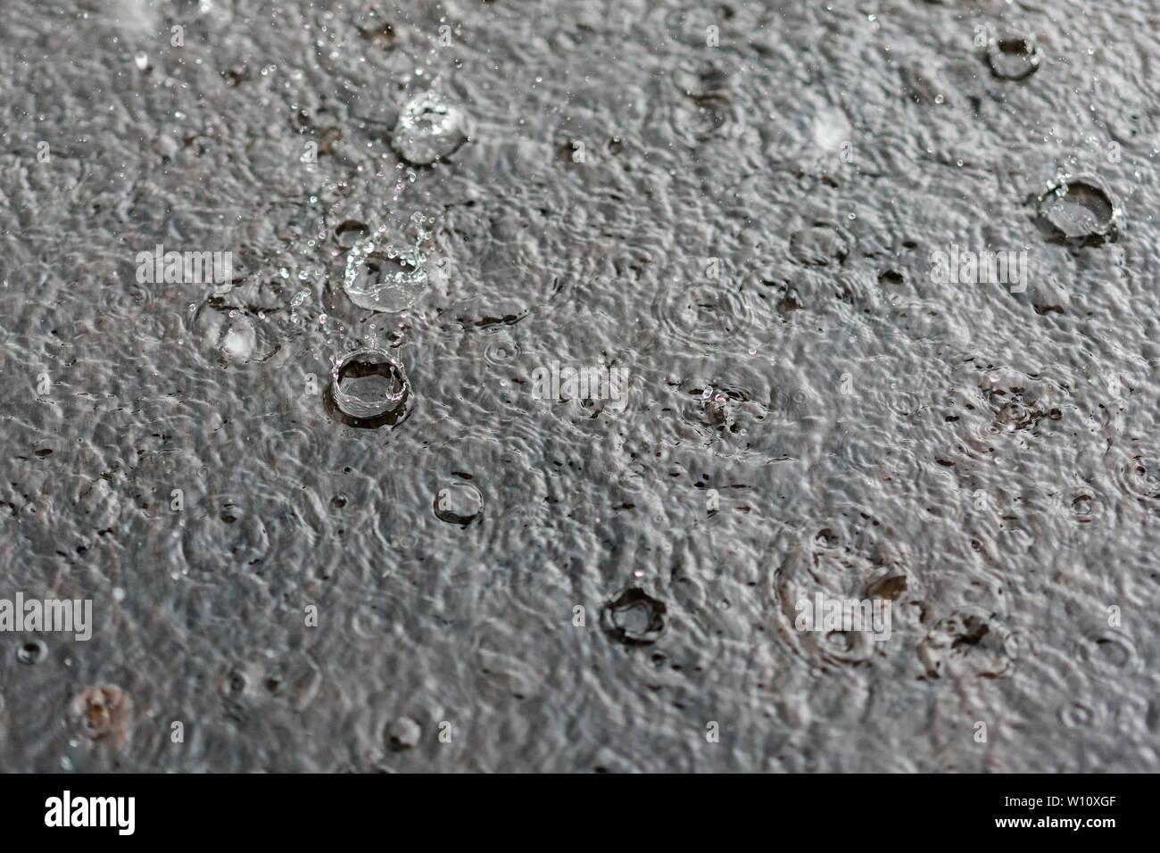 rain gray background. Drops on a puddle Stock Photo - Alamy