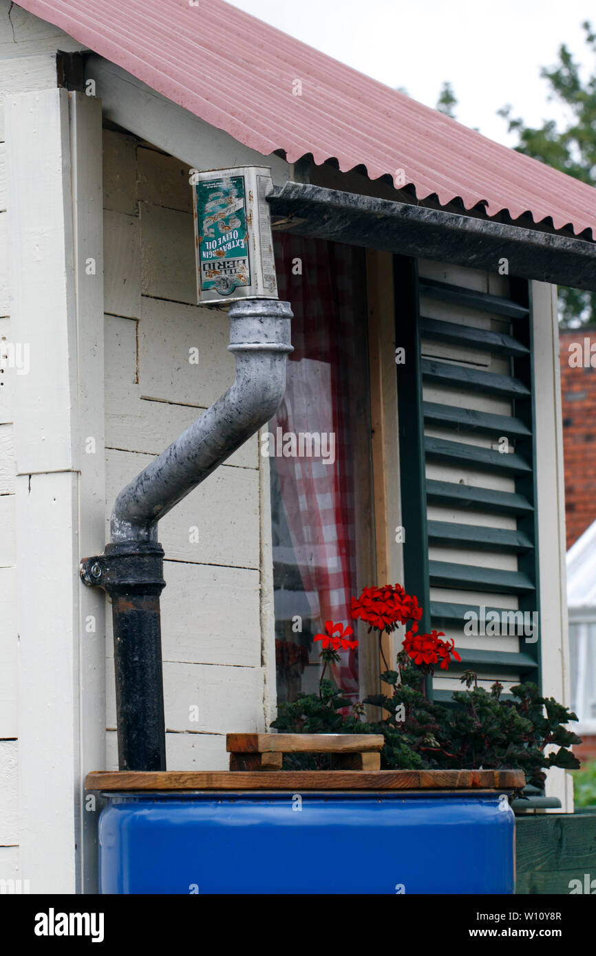 Cooking oil can being used as part of a Heath-Robinson guttering Stock ...