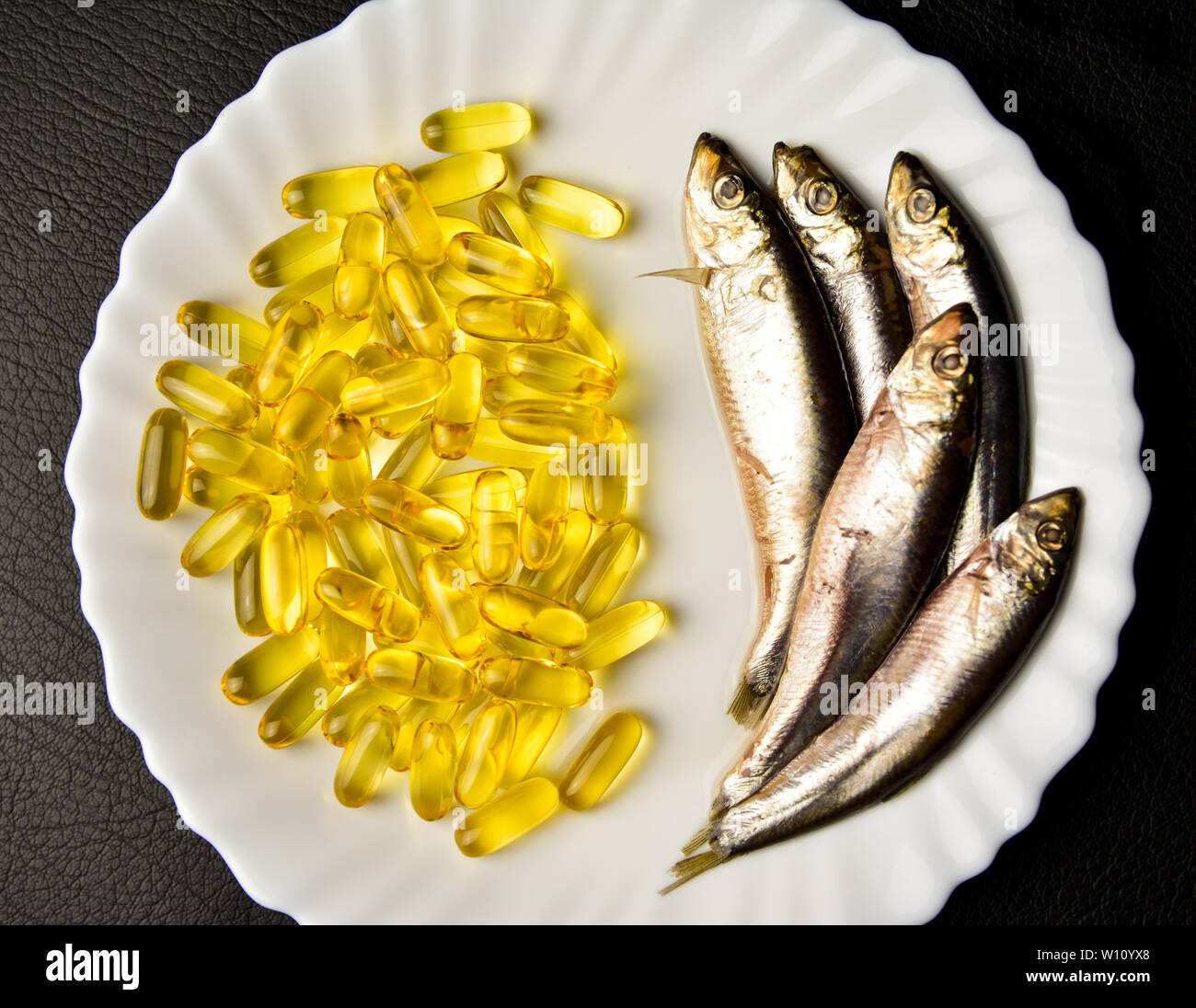 healthy food, fish oil pills and fish on a plate Stock Photo - Alamy