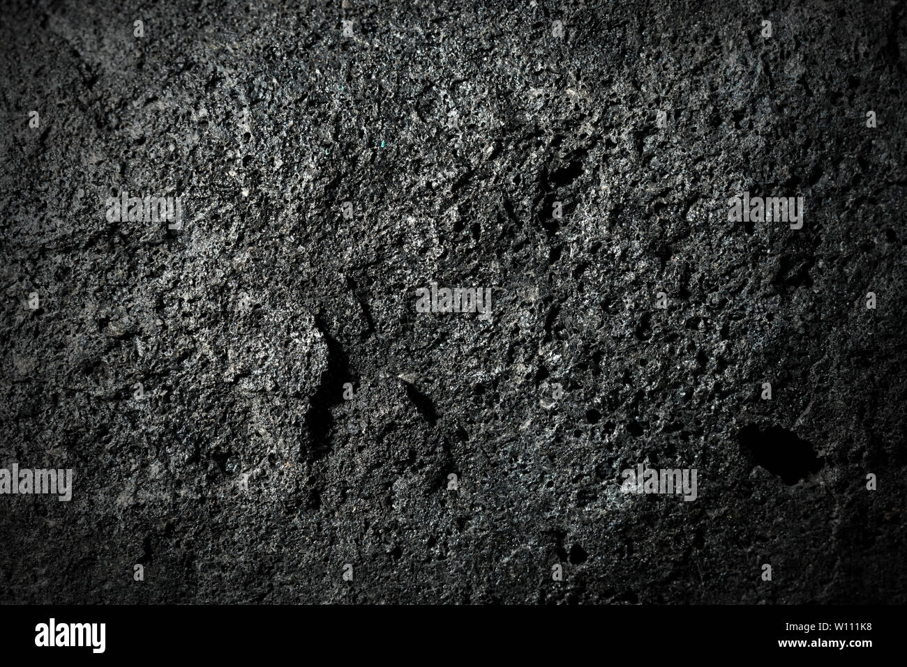 Macro photo of a black volcanic rock (volcanic bomb). Etna volcano ...