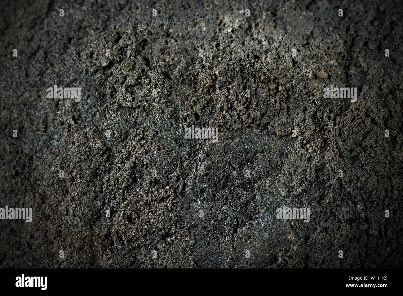 Macro photo of a black volcanic rock (volcanic bomb). Etna volcano ...